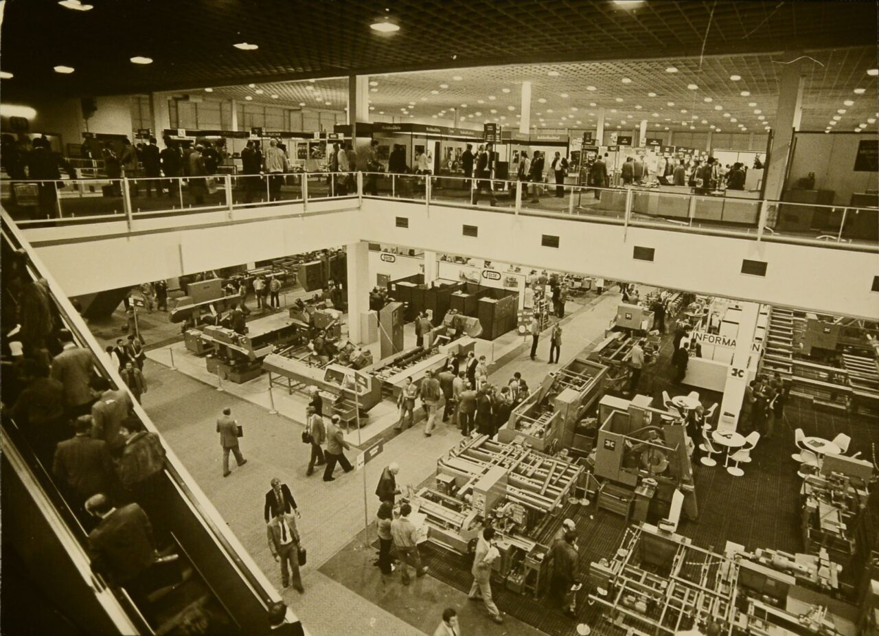 Blick von oben auf eine Messehalle mit den Ständen, Weitwinkel, EMO 1981